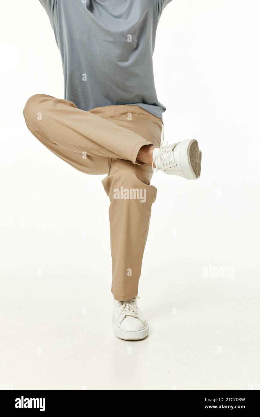 man sitting on invisible chair . guy in white sneakers and beige pants ...