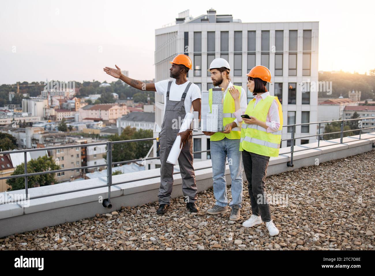 Multicultural architects with equipment working on rooftop Stock Photo ...