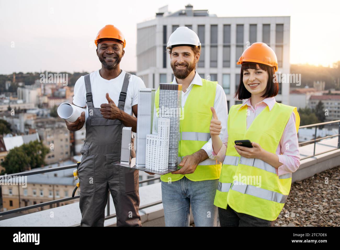 Multicultural designers with equipment posing on rooftop Stock Photo ...