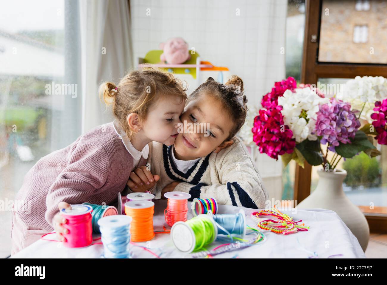Scene of two little girls playing together at home, little girl giving ...