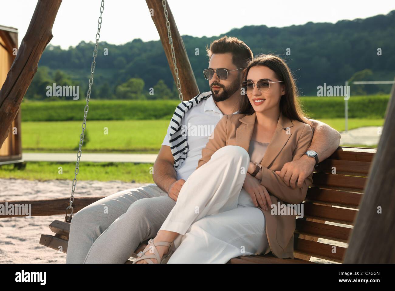 Romantic date. Beautiful couple spending time together on swing bench ...