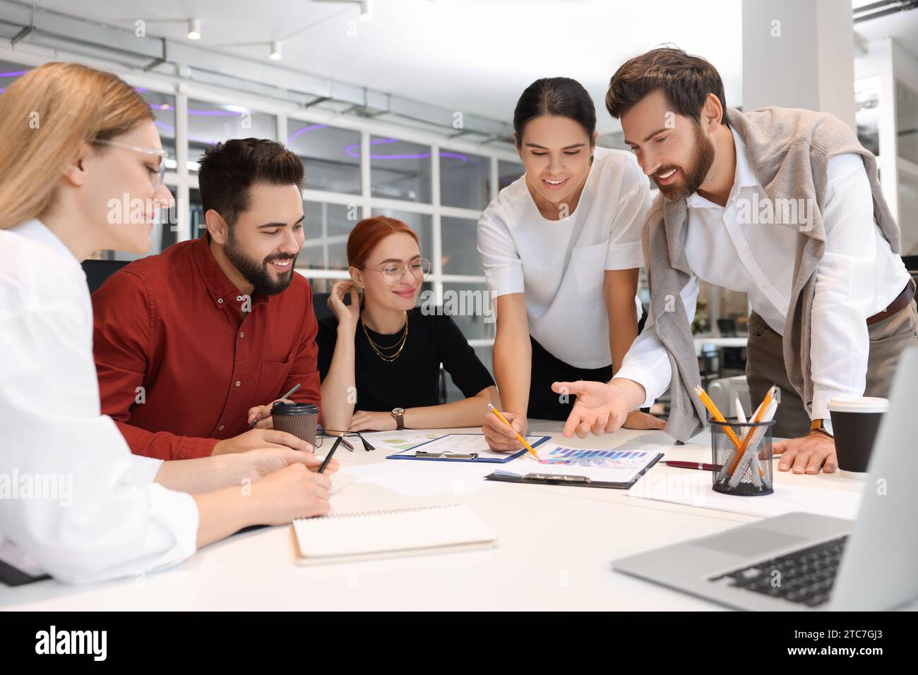 Team of employees working together in office Stock Photo - Alamy