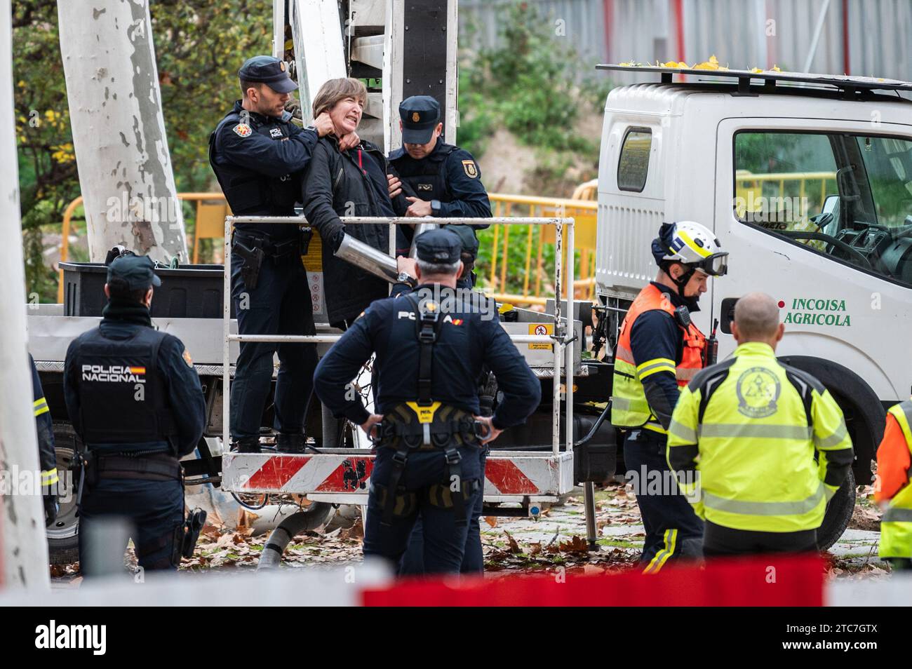 A climate activist chained with metal tubes to a crane is removed by ...