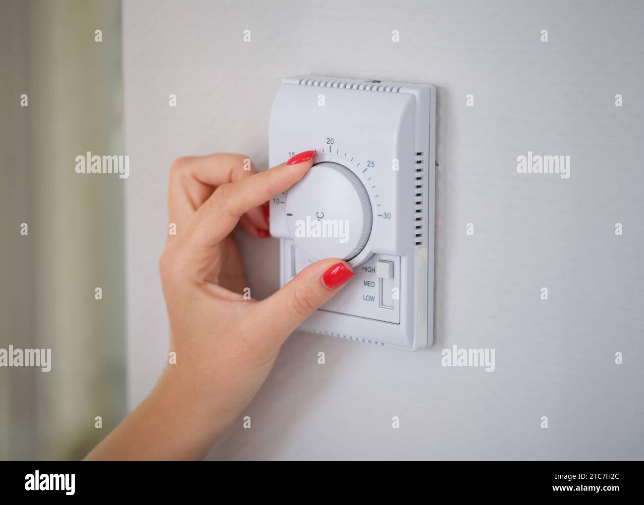 Female hand adjusting temperature of air conditioner with roller ...