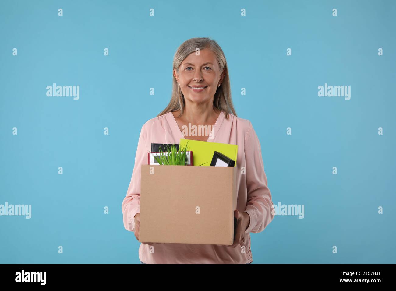Happy unemployed senior woman with box of personal office belongings on ...