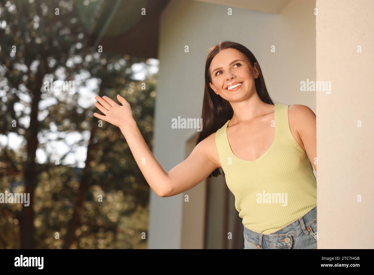 Neighbor greeting. Happy woman waving near house outdoors Stock Photo ...