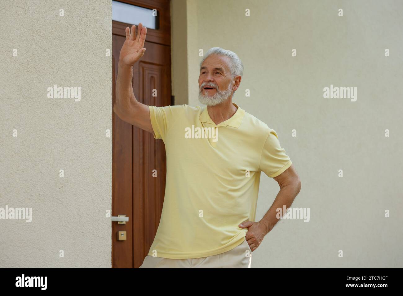 Neighbor greeting. Happy senior man waving near house outdoors Stock ...