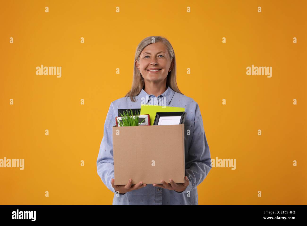 Happy unemployed senior woman with box of personal office belongings on ...