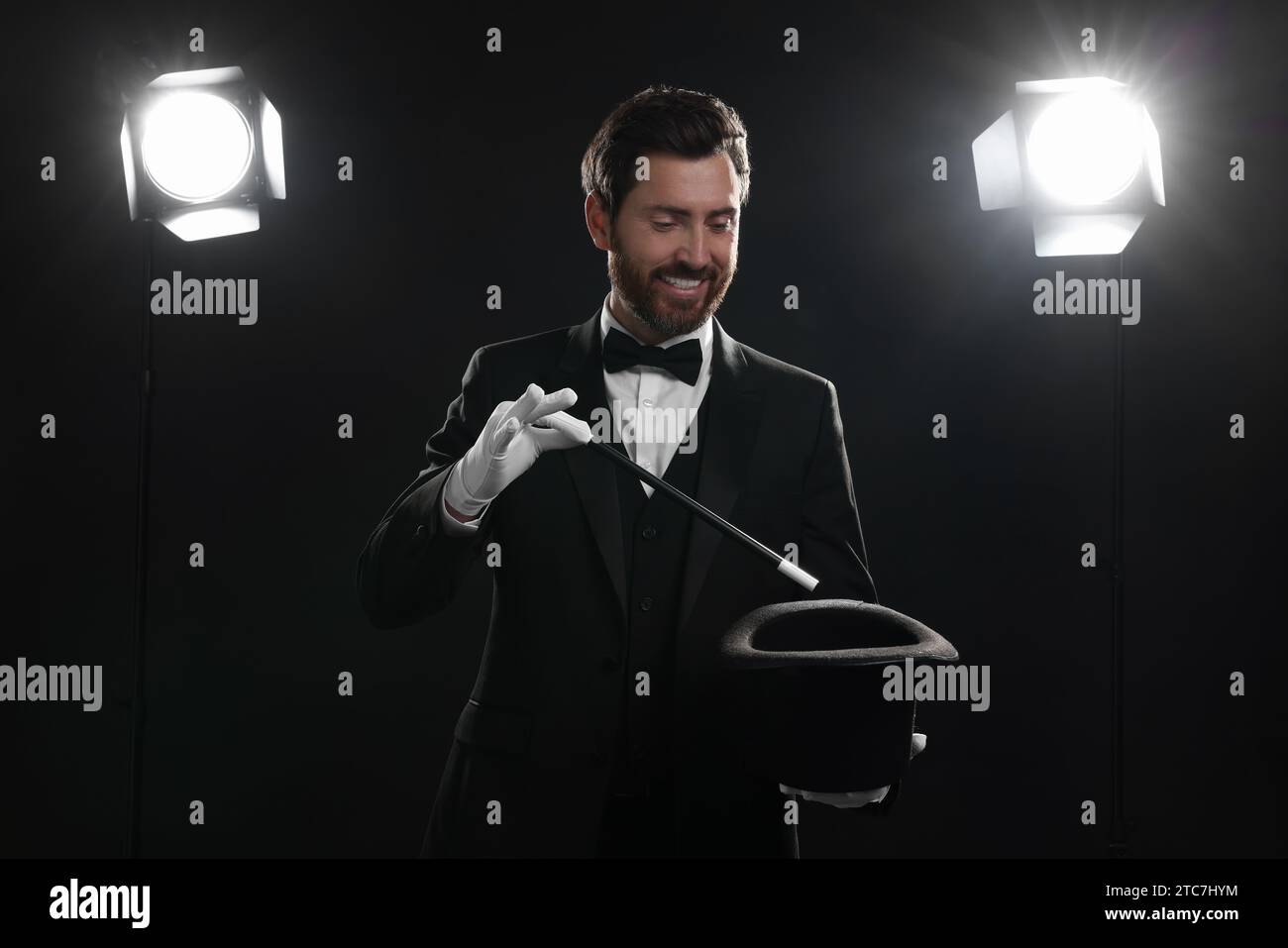 Happy magician showing magic trick with top hat on stage Stock Photo ...