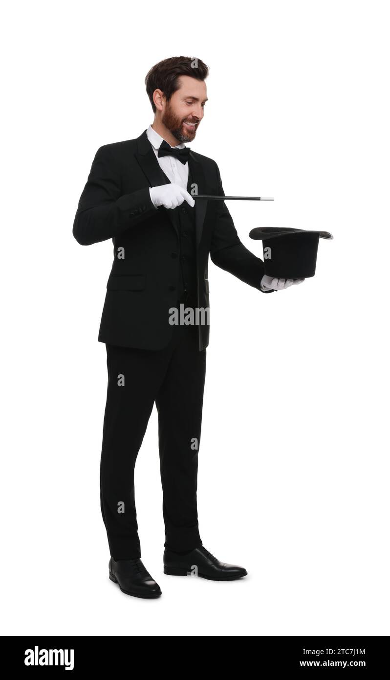 Happy magician showing magic trick with top hat on white background ...