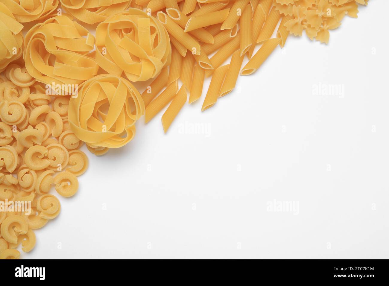 Different types of pasta on white background, flat lay. Space for text ...