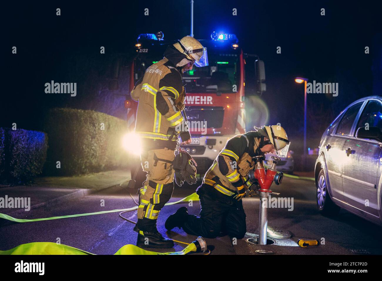 Zwei Feuerwehrmänner beim Aufbau einer Löschwasserversorgung. Im ...
