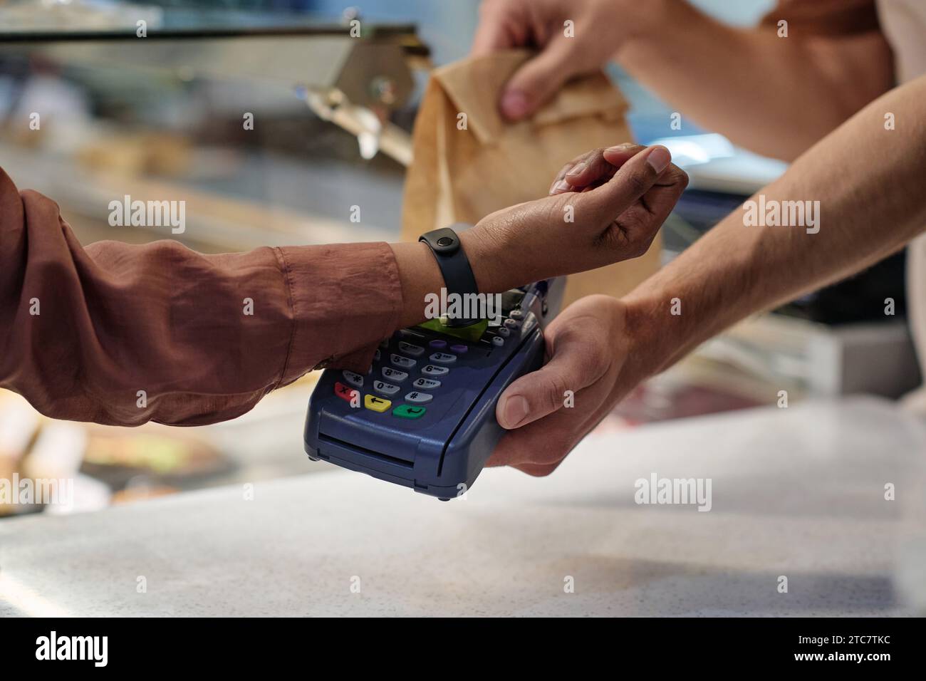 Unrecognizable woman paying with smartwatch for takeaway order, unknown ...