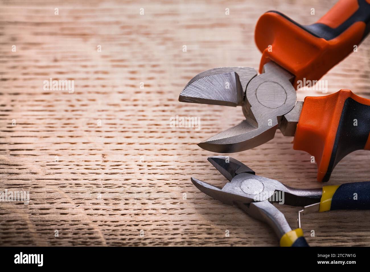 Horizontal view two opened nippers close up on wooden board ...