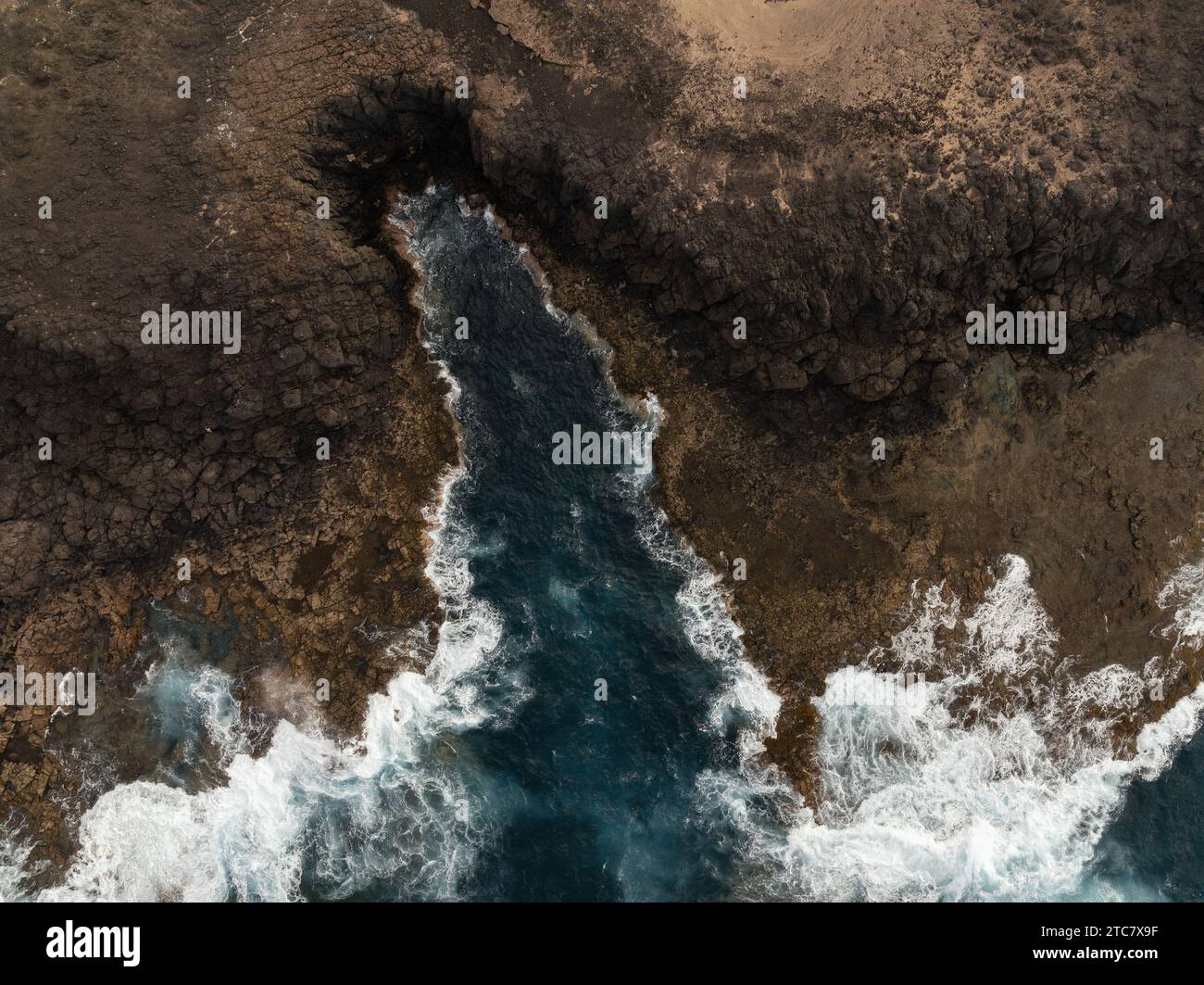 Aerial shot of a narrow water channel between rugged terrain leading ...