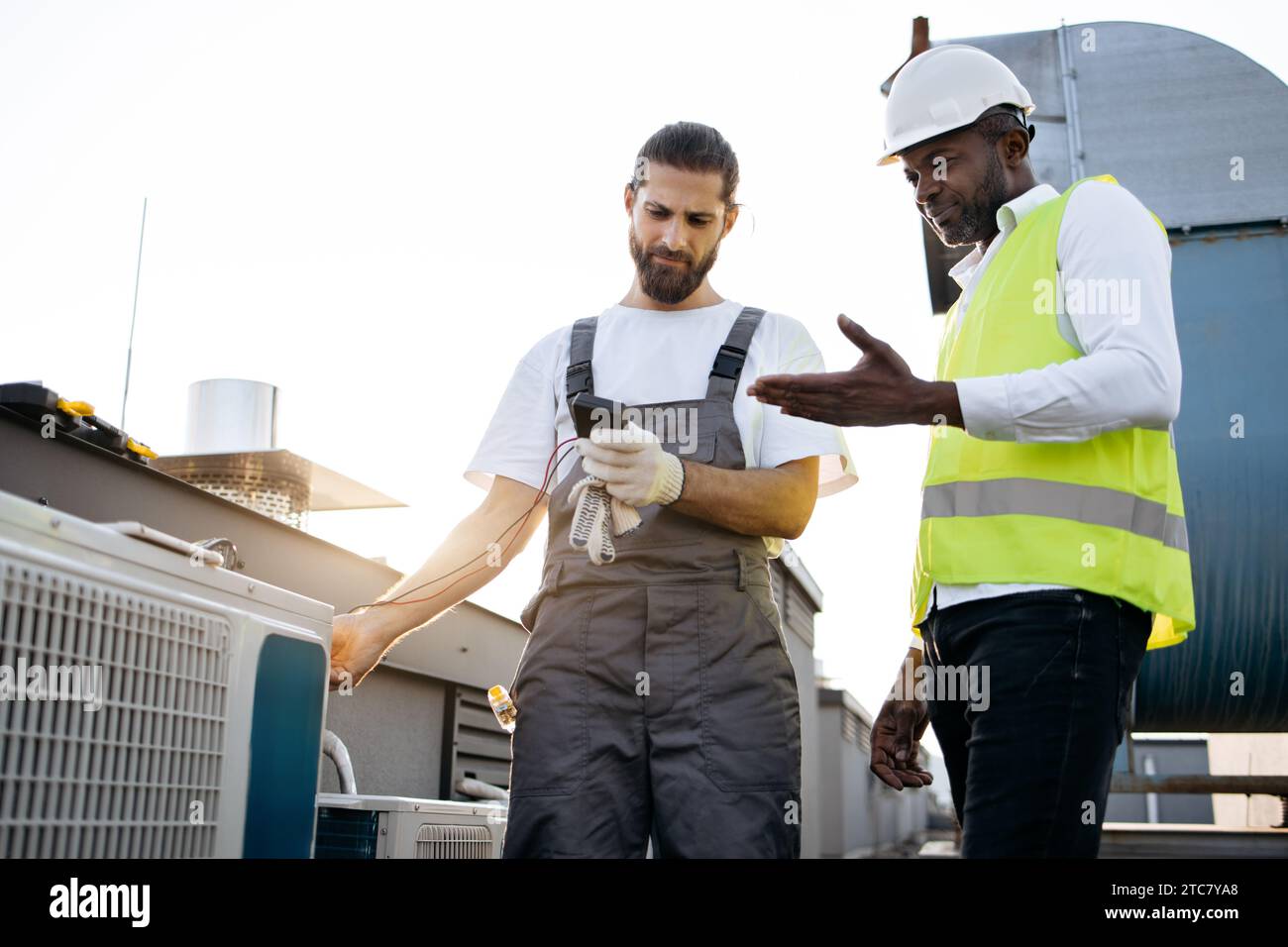 Construction men using multimeter for conditioner on rooftop Stock ...