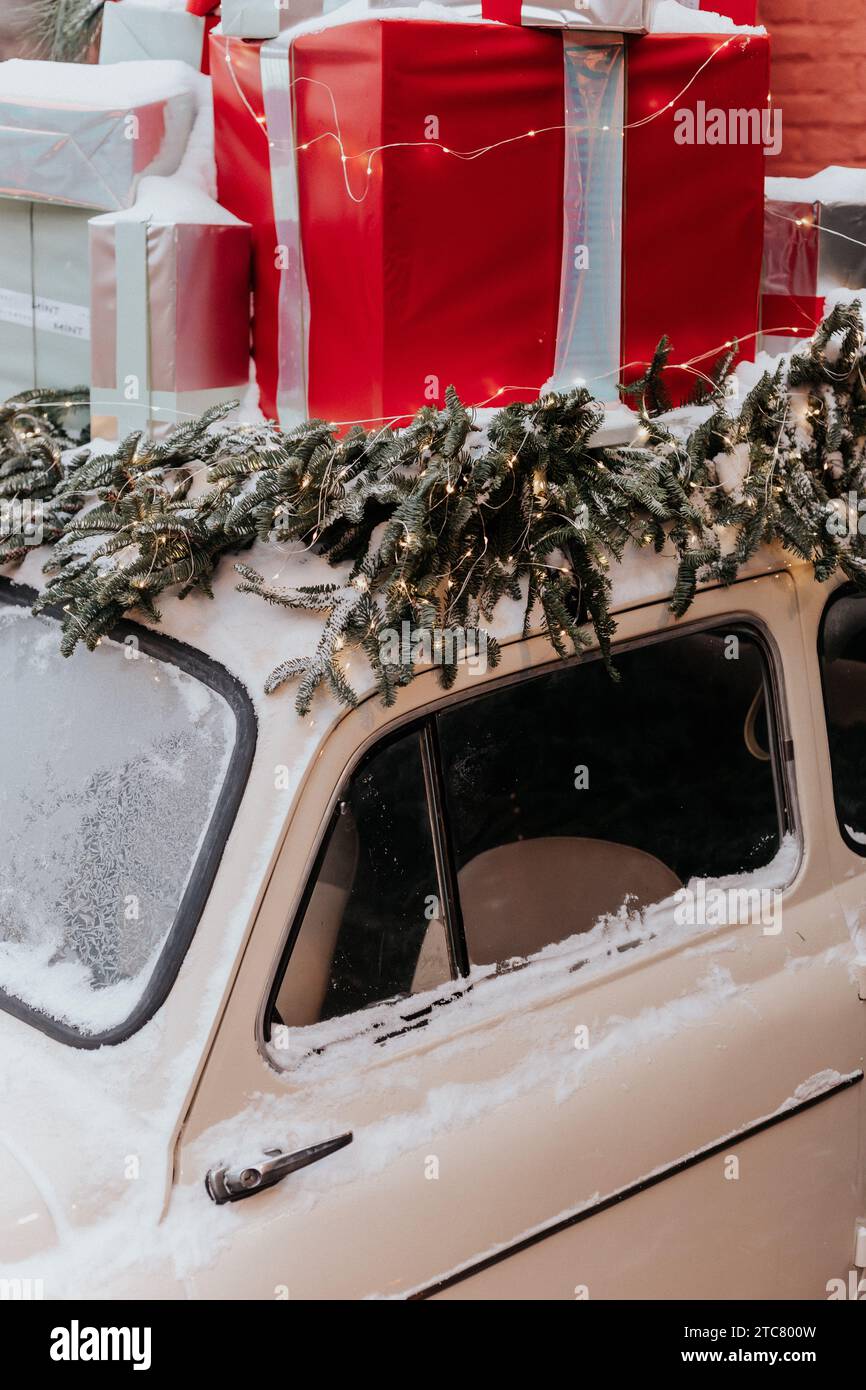 Retro car with christmas tree branches and gift boxes on the roof ...