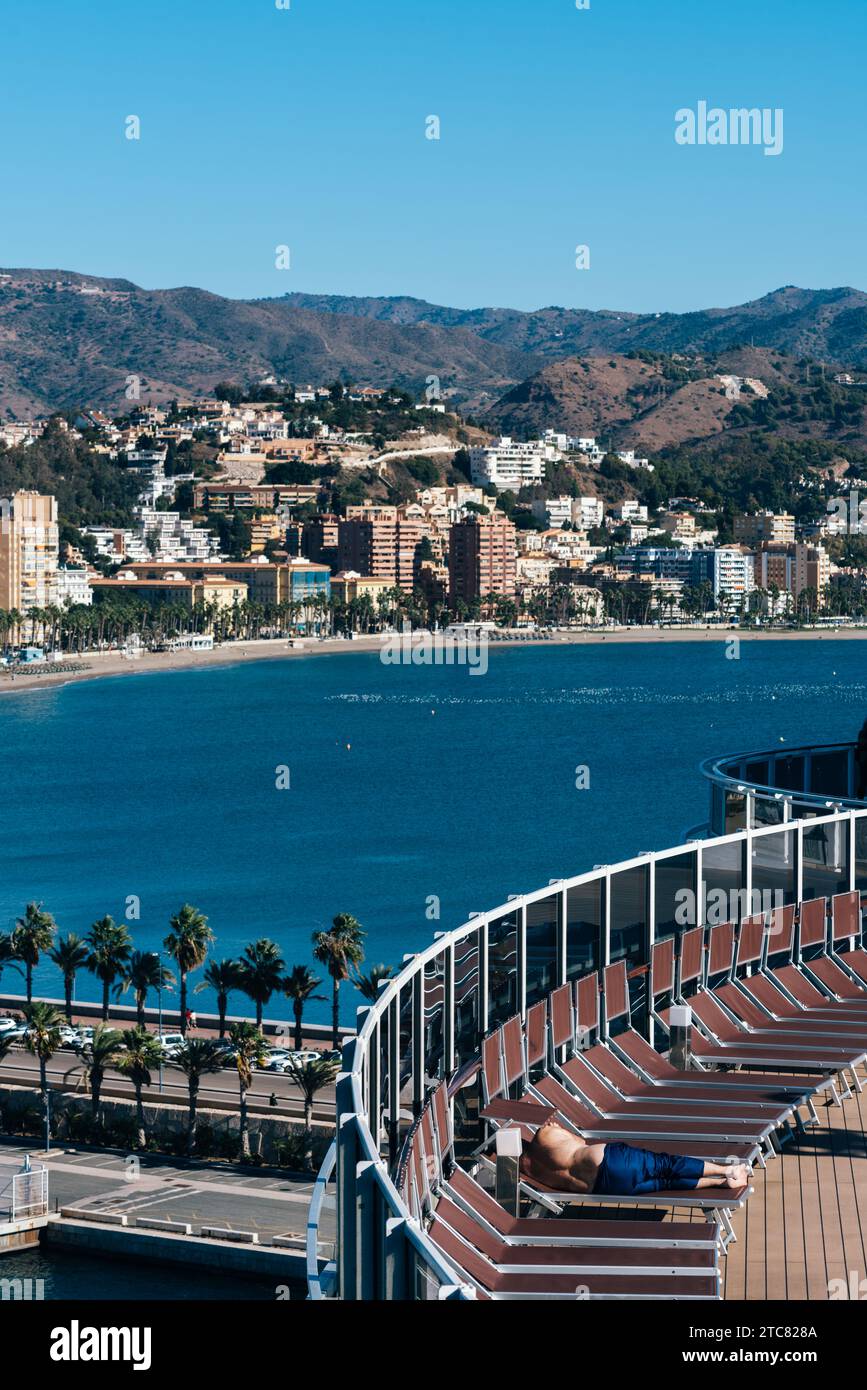 Unidentifiable man relaxing on a sun lounger aboard a cruise ship ...