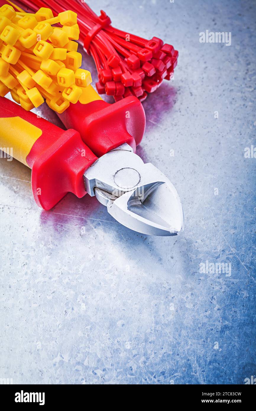 Wire cutter self-locking tying cables on scratched metallic background ...