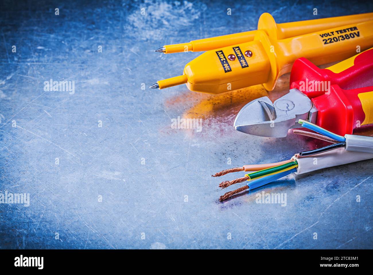 Yellow electrical tester wires nippers on metallic background ...