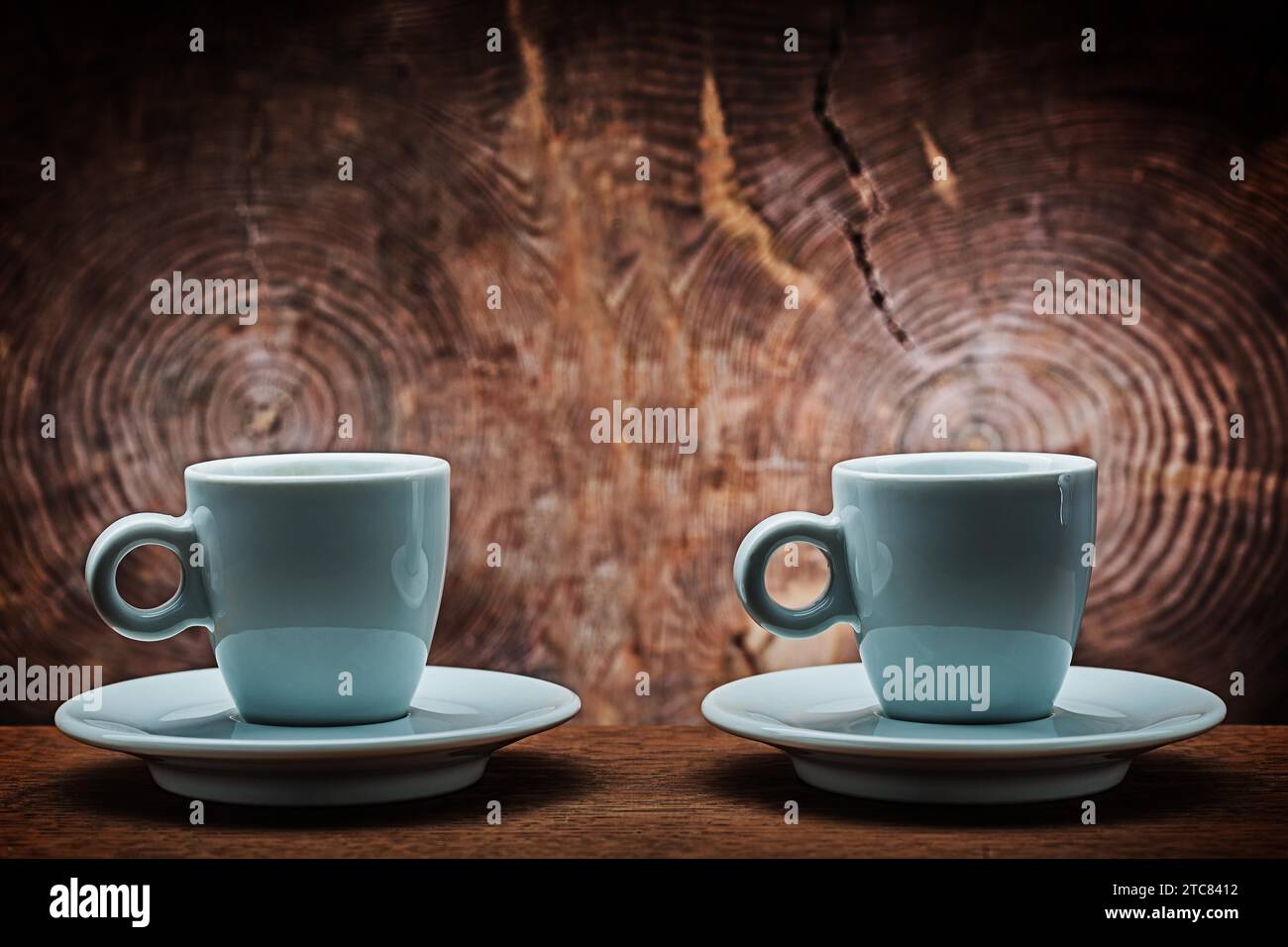 Two little white ceramic coffee cups on vintage wood background with ...
