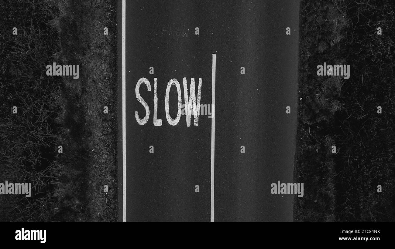 An aerial view of an asphalt road with the word: slow Stock Photo - Alamy