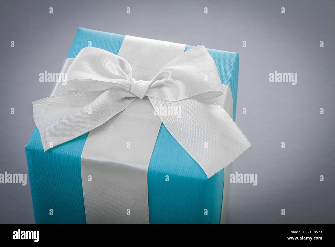 Classical blue giftbox with white ribbon on gray background Stock Photo - Alamy