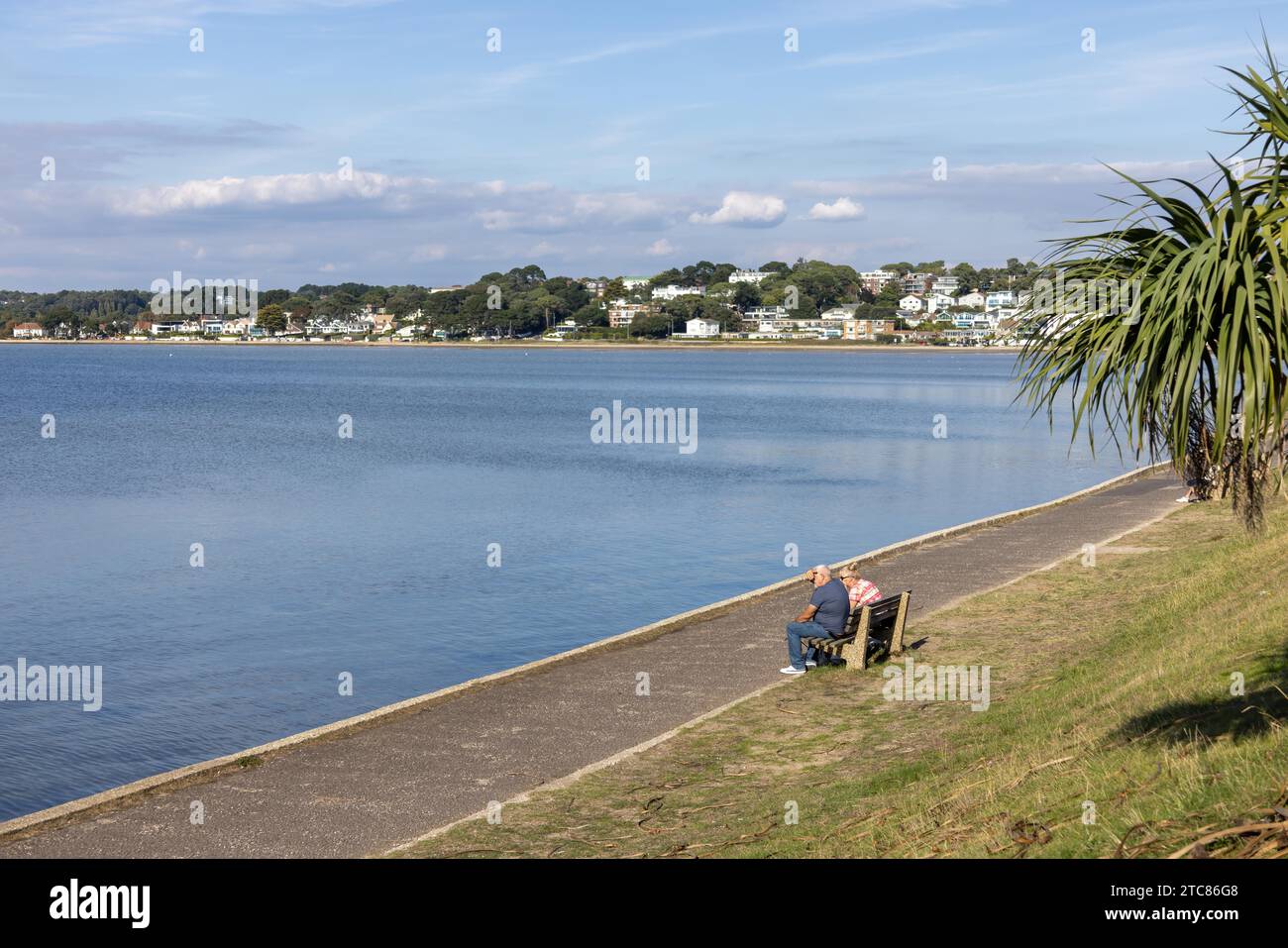 Sandbanks, Dorset, UK, September 21 : Two people sitting on a bench ...