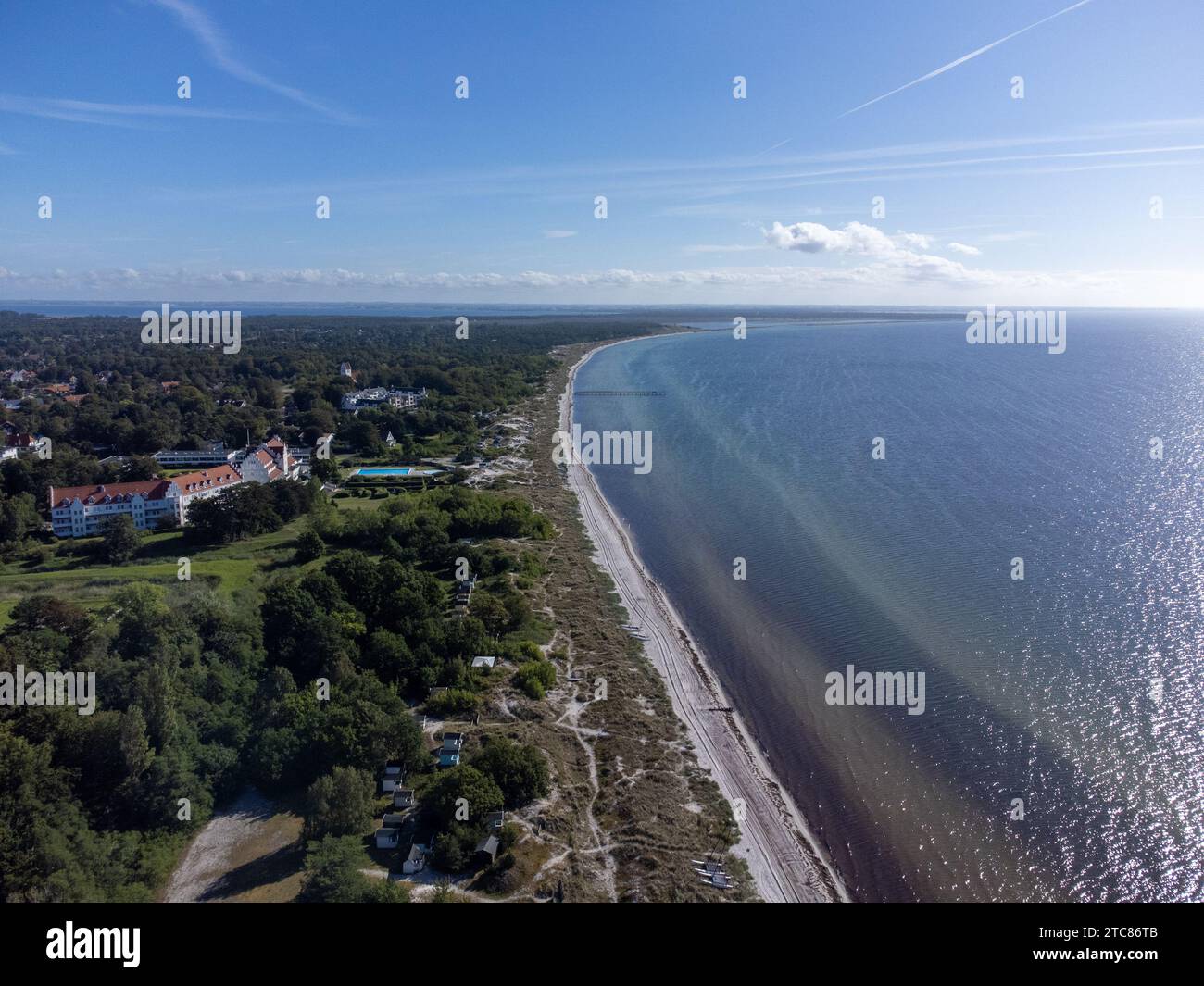An idyllic beach scene featuring a sandy shoreline, crystal blue waters ...