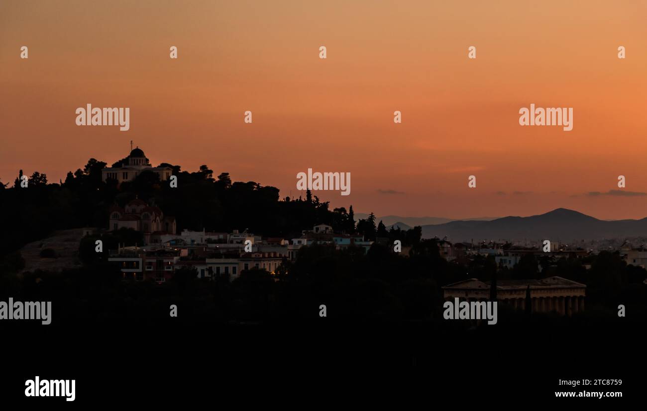 A picture of the sun setting over a hill in Athens Stock Photo - Alamy