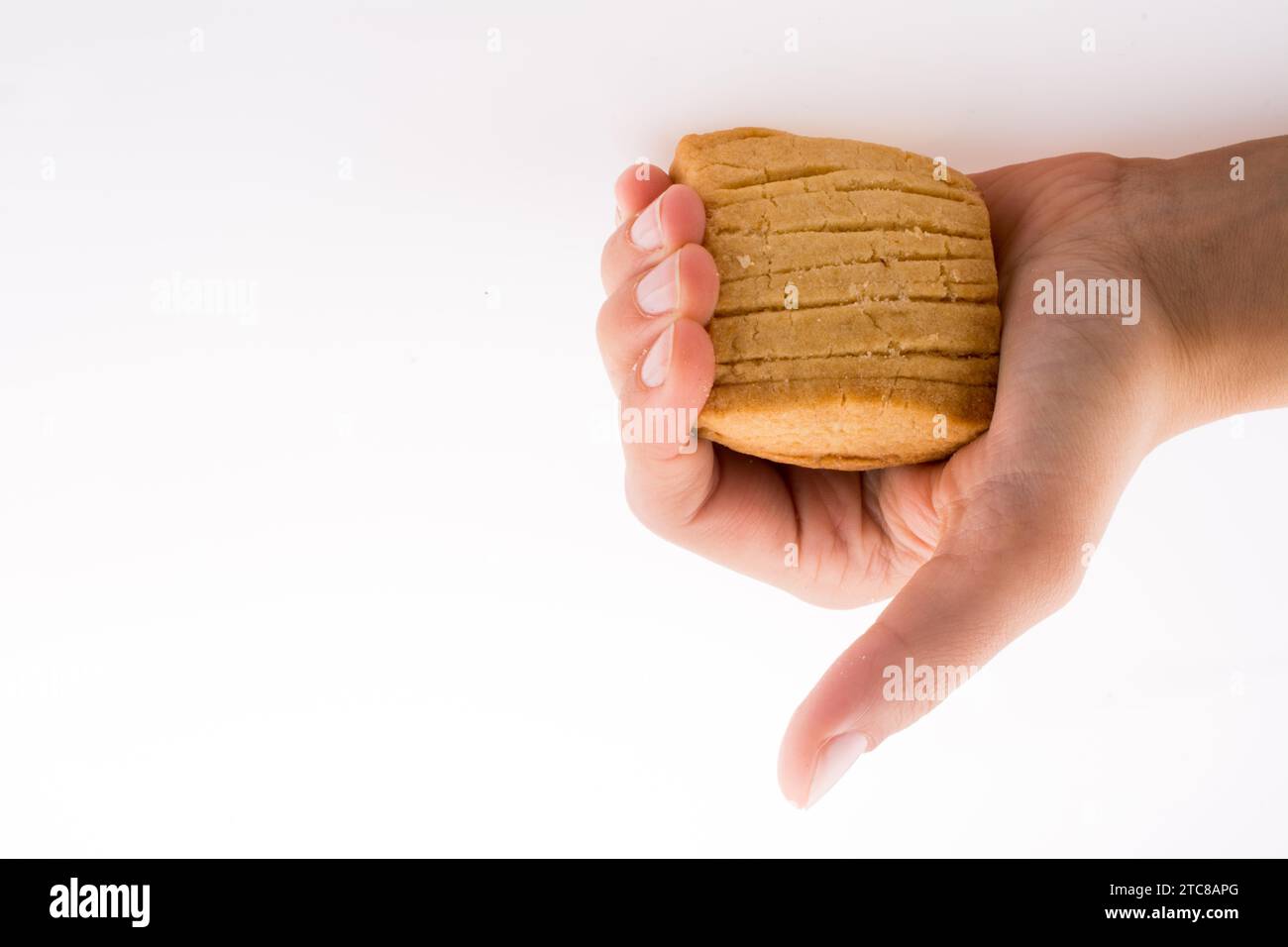 Hand holding square cookie a white background Stock Photo - Alamy