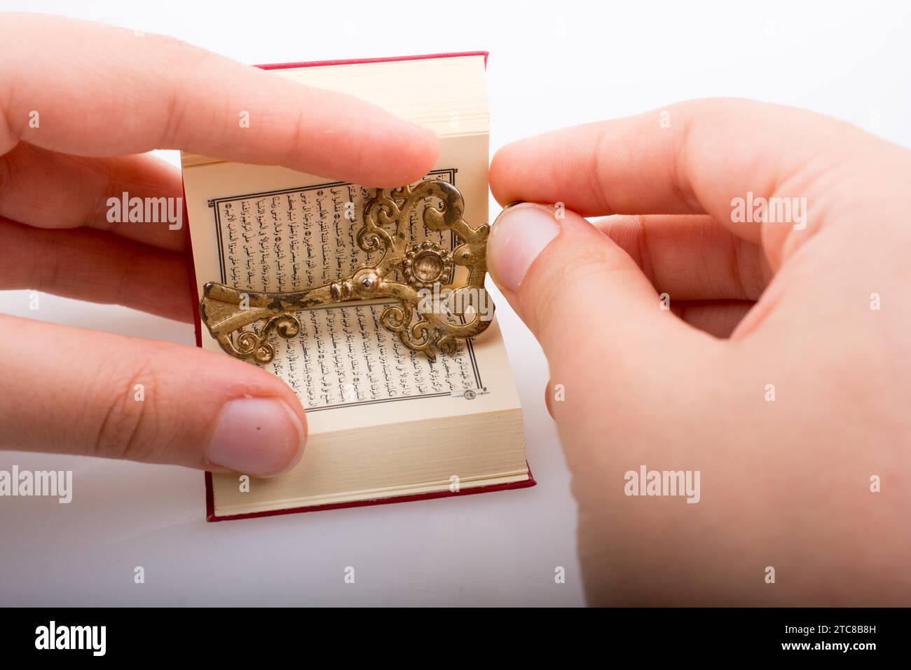 Hand holding Key and Islamic Holy Book Quran in mini size Stock Photo ...