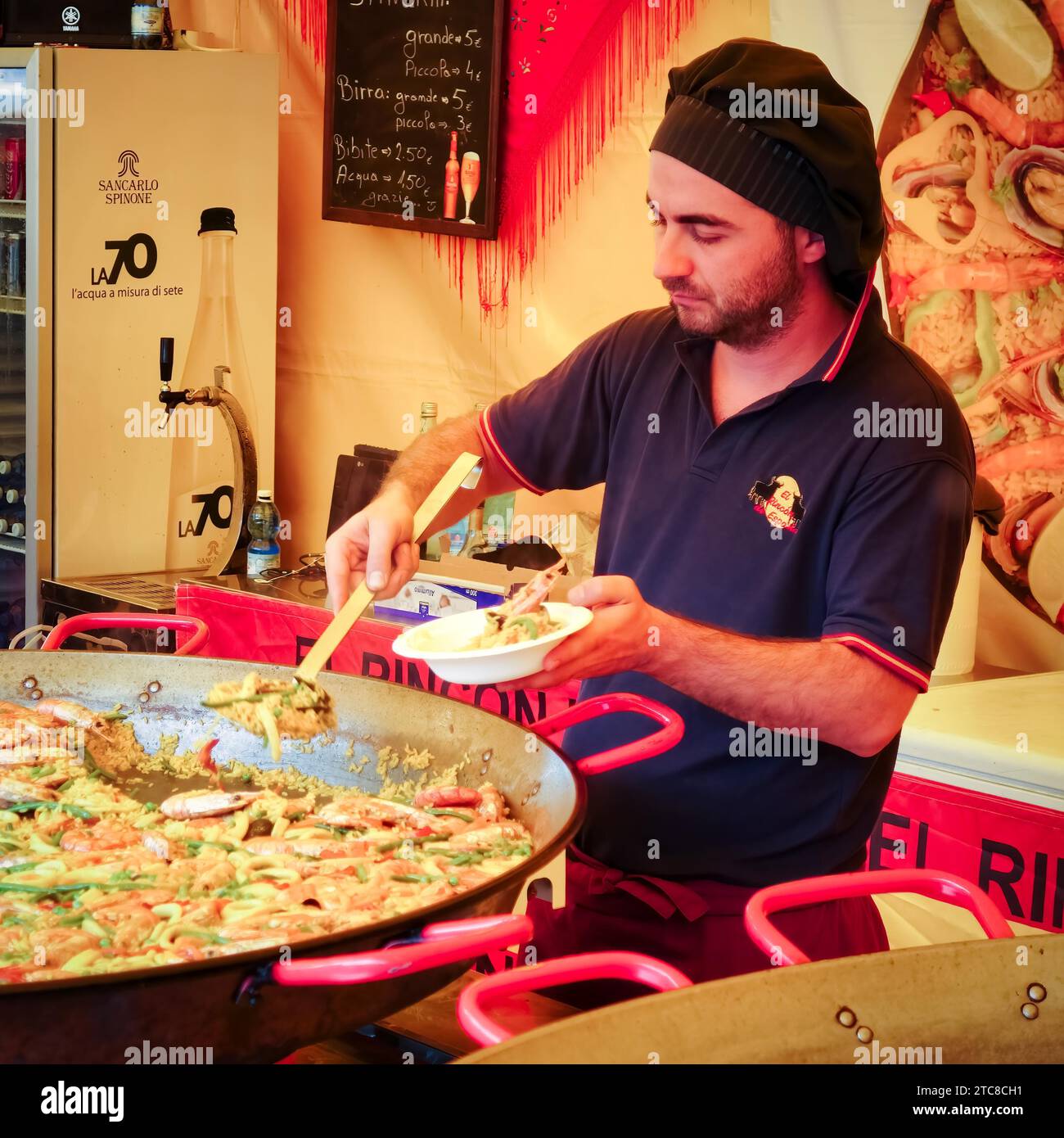 Man selling paella on a market stall in Bergamo Stock Photo - Alamy