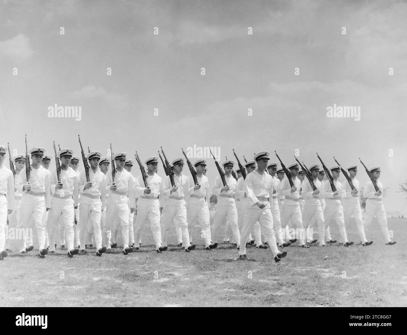 Naval commander leads a group of marching soldiers carrying rifles ...
