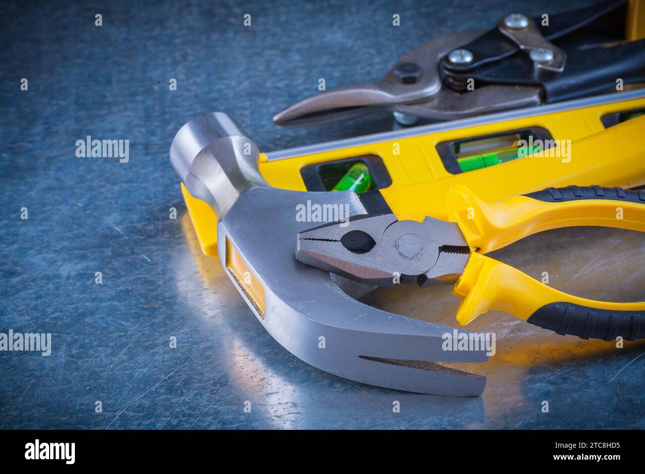 Pliers claw hammer construction level and tin snips on scratched ...