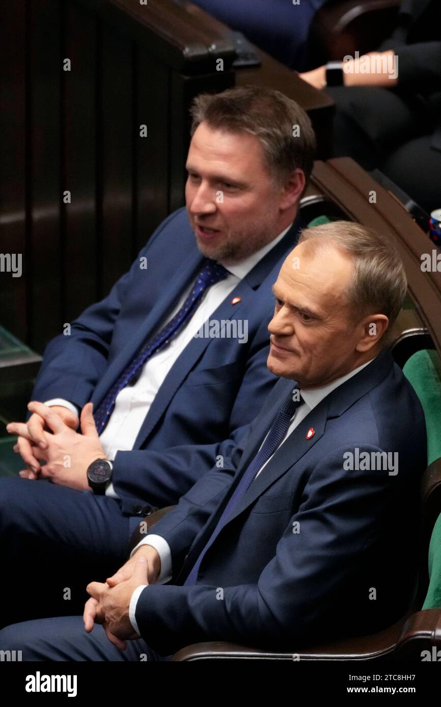 The leader of Poland's opposition Donald Tusk, right, sits in the parliament after Poland's ...