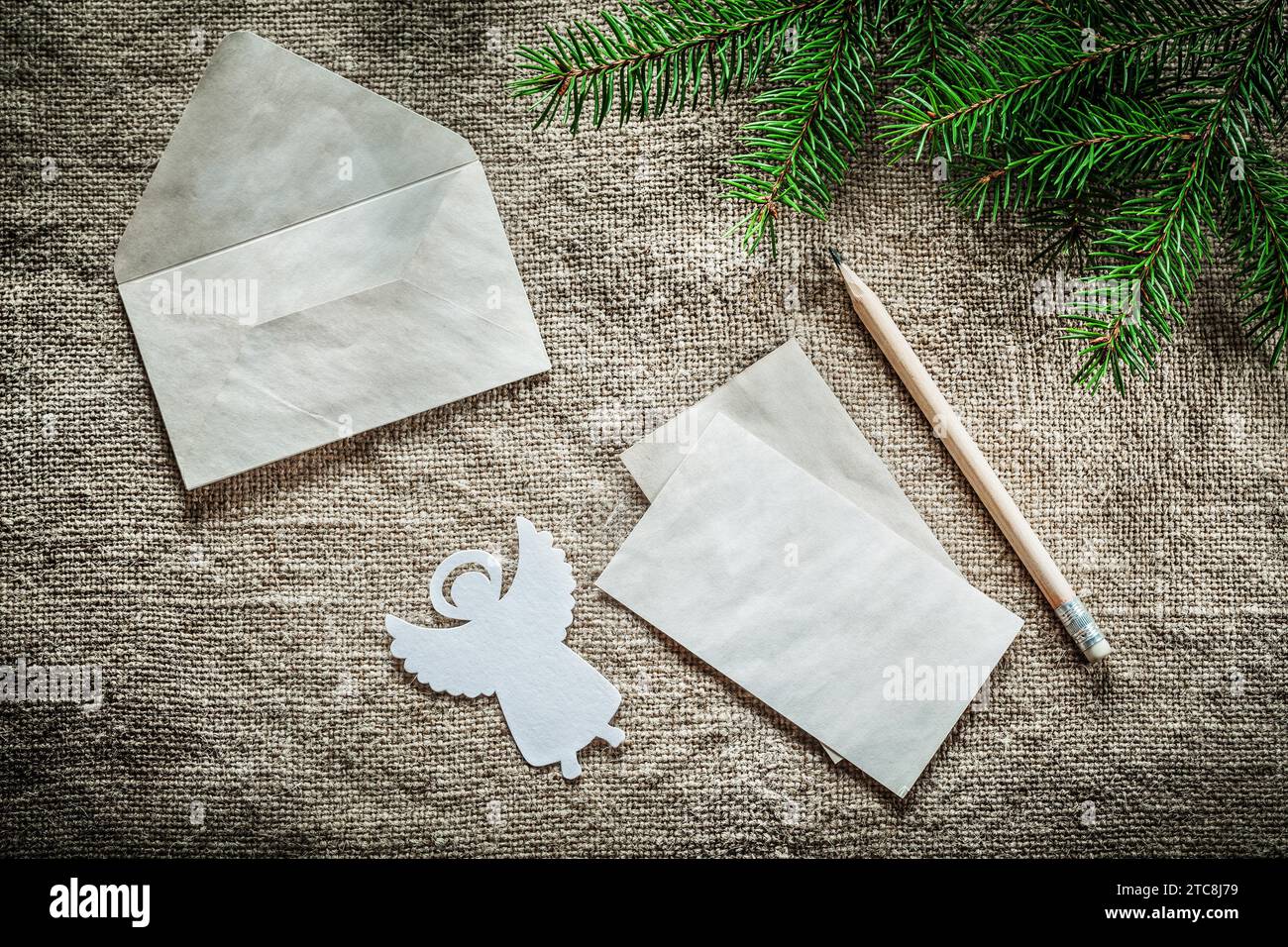 Pine tree twig envelope letter pencil angel on sacking background Stock ...