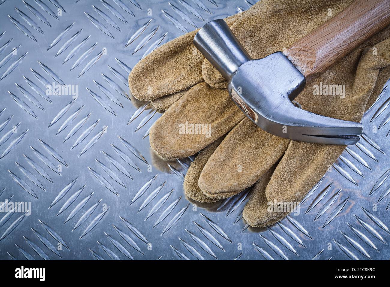 Claw hammer safety gloves on grooved metal plate construction concept ...