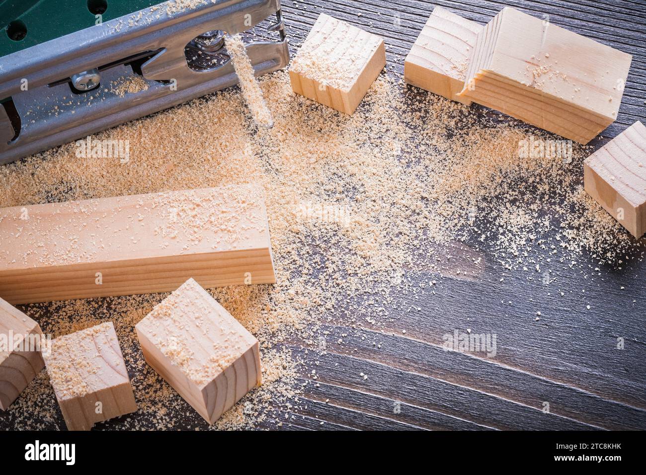 Electric jigsaw sawdust and wooden bricks on vintage wood board ...