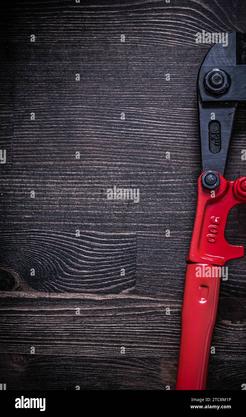 Metal bolt cutter on wooden board vertical version construction concept ...