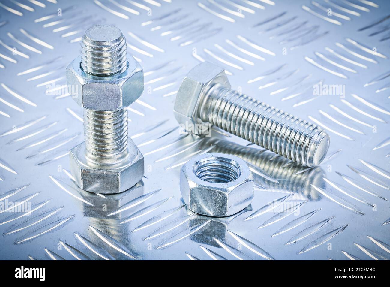 Stainless screwbolts and threaded construction nuts on corrugated metal ...