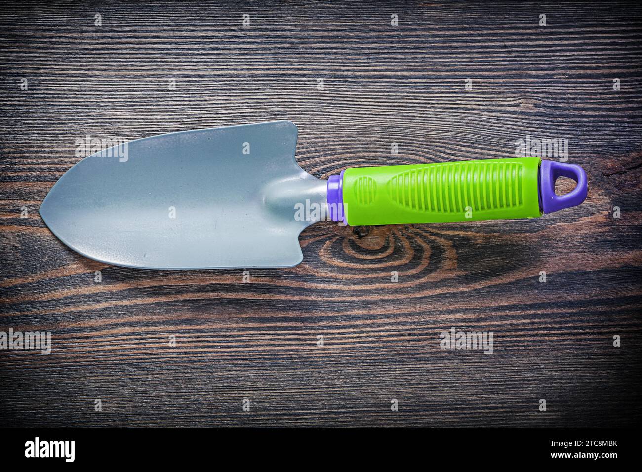 Stainless hand spade with green handle on wood board agriculture ...