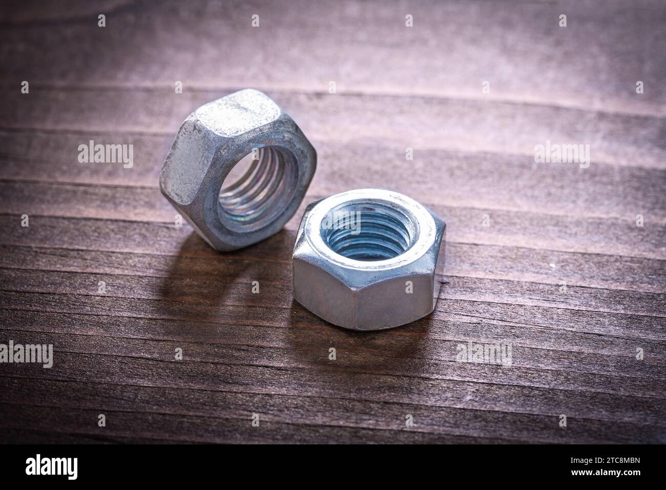 Stainless threaded screw nuts on vintage wooden board repairing concept ...