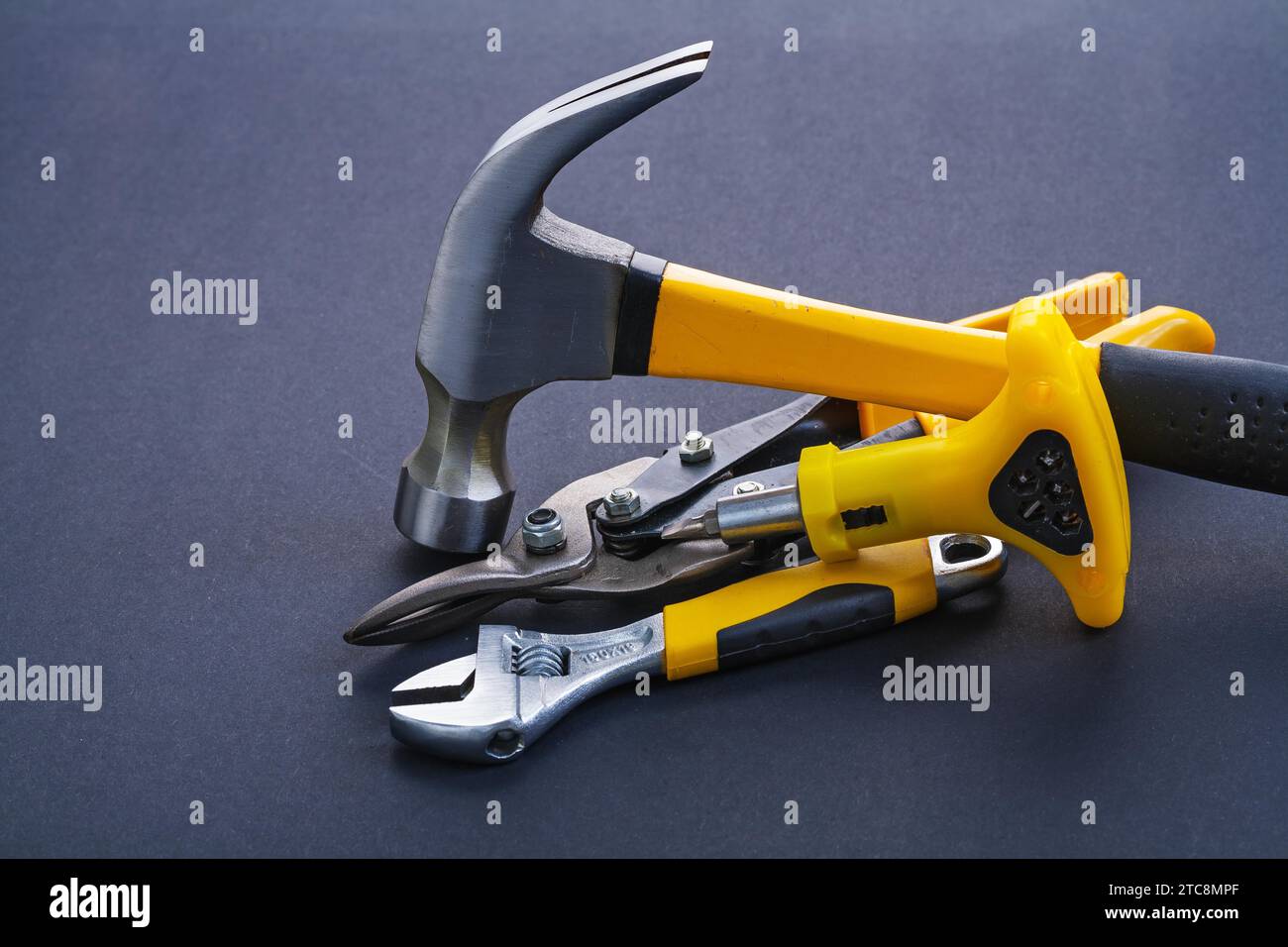 Hand screwdriver steel cutter claw hammer with yellow handles on black ...