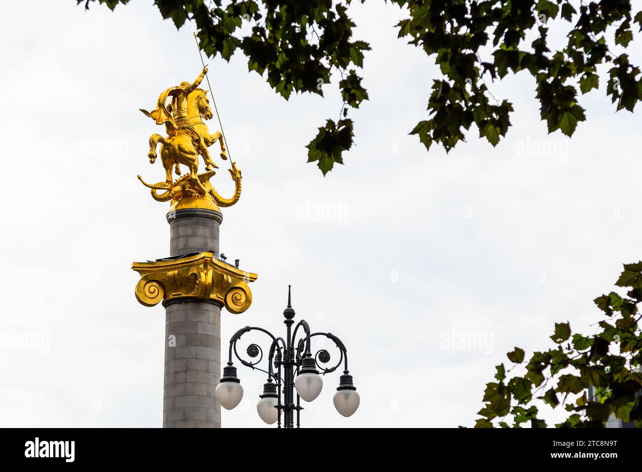 Tbilisi, Georgia - September 22, 2023: green leaves and golden statue ...