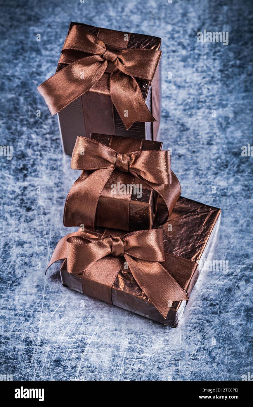 Giftboxes packed in crumpled glittery paper on scratched metallic ...