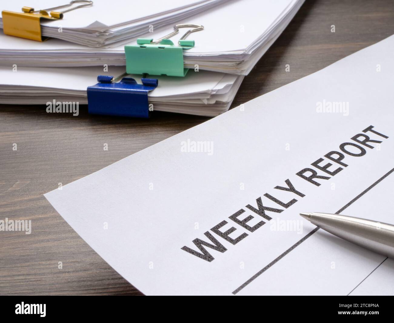 Weekly report and stack of papers Stock Photo - Alamy