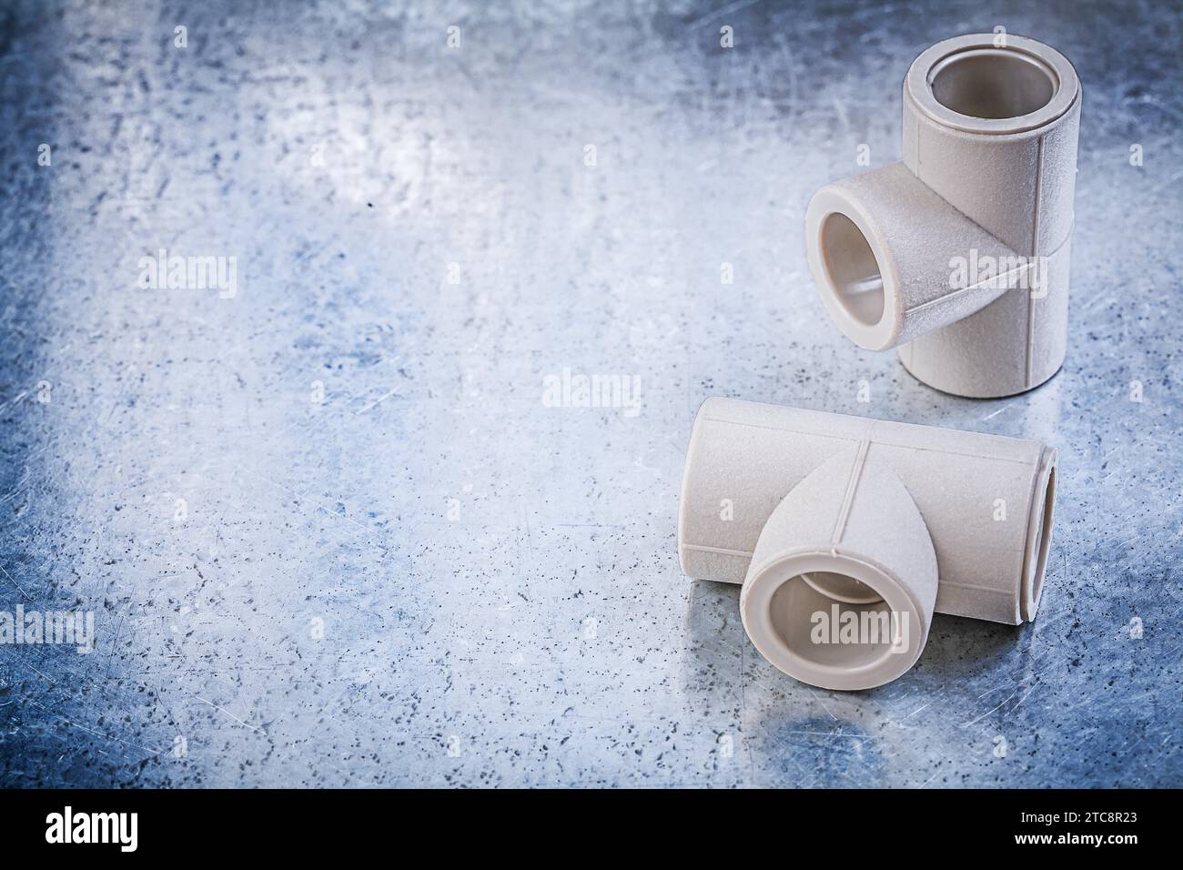 Plastic T-tube connectors on metallic background construction concept ...