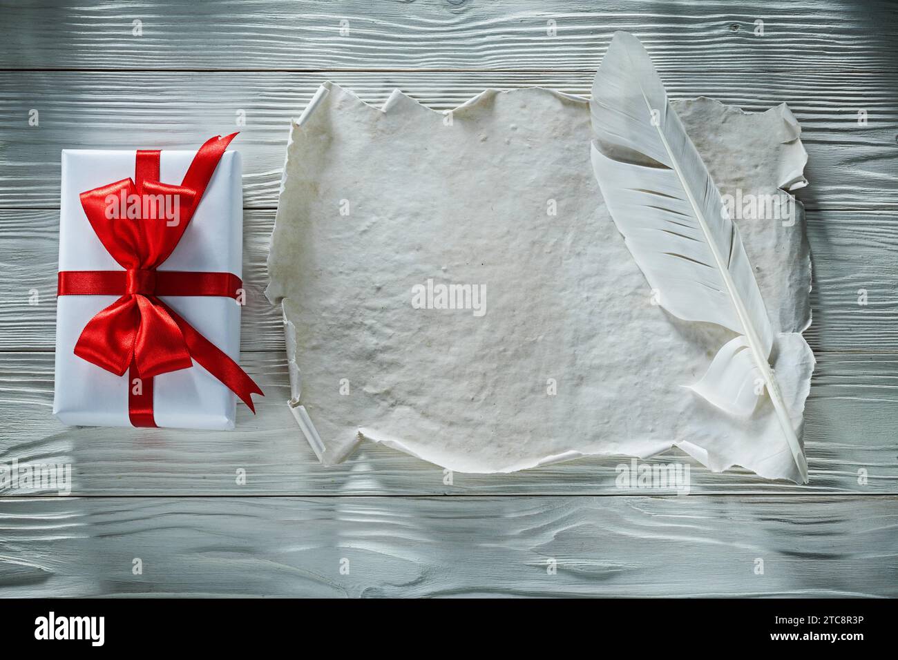 Plume vintage paper sheet wrapped gift box on wooden board Stock Photo ...