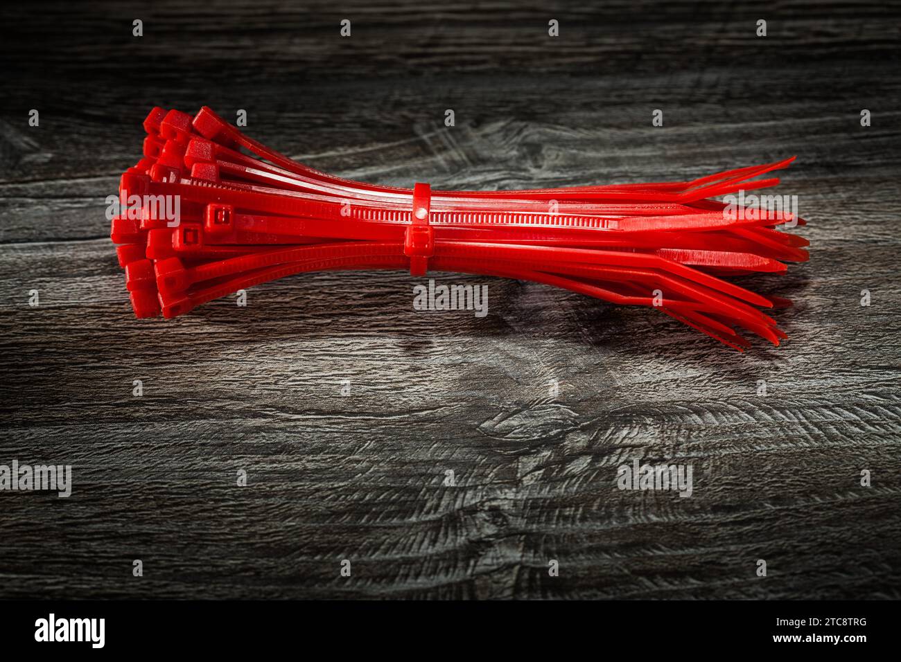 Bundles of red plastic cables on an old wooden board Stock Photo - Alamy
